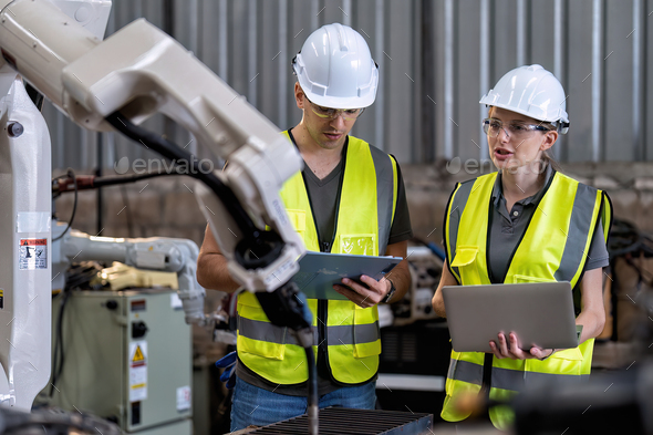 In robotic training instructor teach girl engineer to program robot arm ...