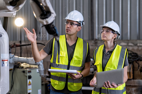 In robotic training instructor teach girl engineer to program robot arm ...