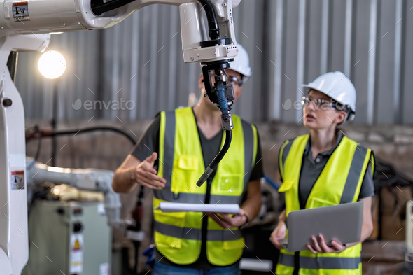 In robotic training instructor teach girl engineer to program robot arm ...