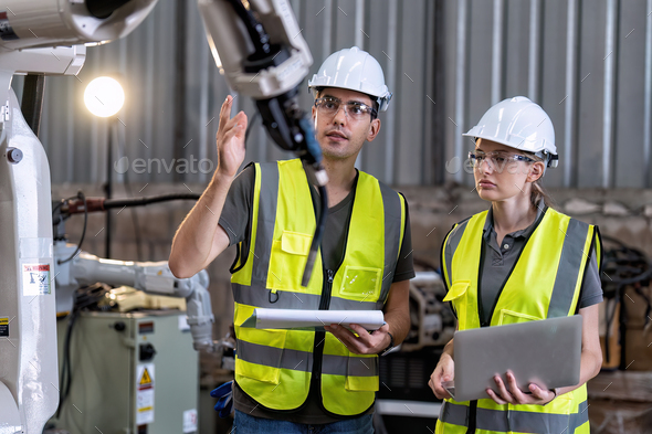 In robotic training instructor teach girl engineer to program robot arm ...