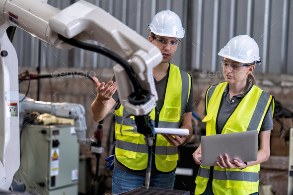 In robotic training instructor teach girl engineer to program robot arm ...