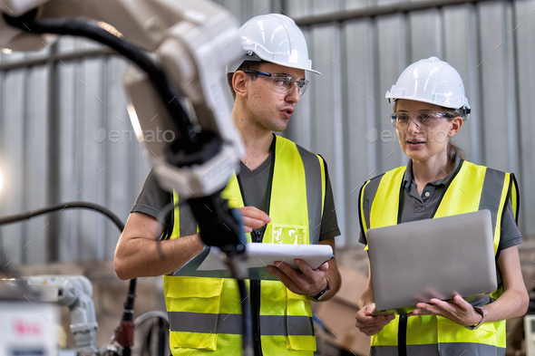 In robotic training instructor teach girl engineer to program robot arm ...