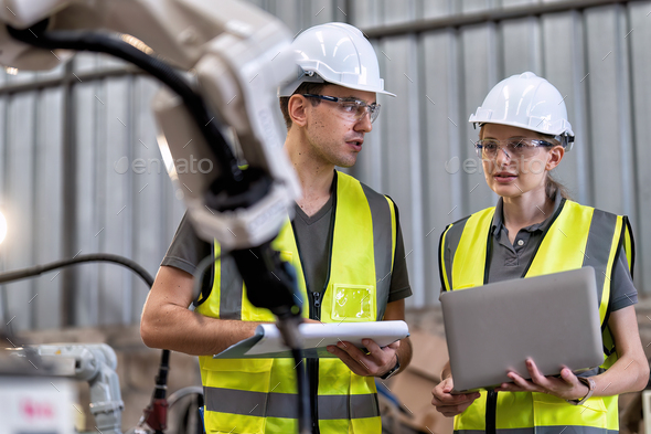 In robotic training instructor teach girl engineer to program robot arm ...
