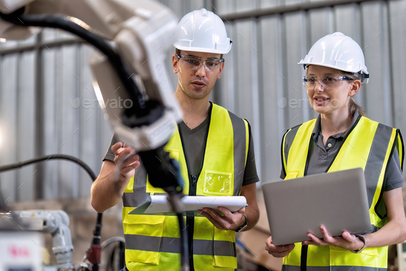 In robotic training instructor teach girl engineer to program robot arm ...