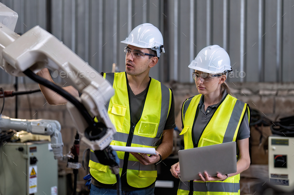 In robotic training instructor teach girl engineer to program robot arm ...