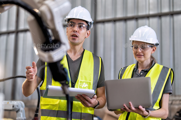 In robotic training instructor teach girl engineer to program robot arm ...