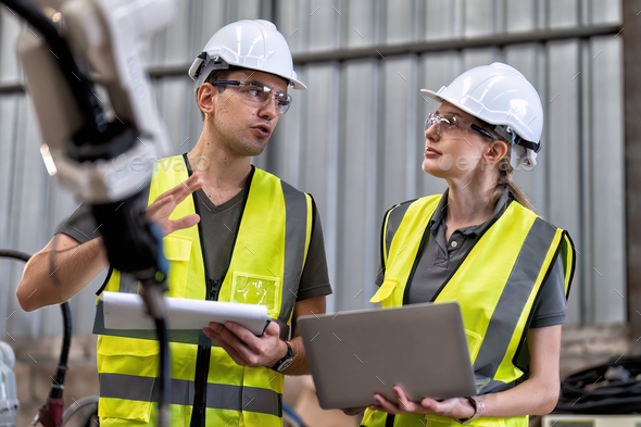 In robotic training instructor teach girl engineer to program robot arm ...