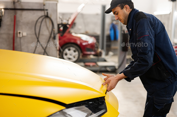 Mechanic open hood of yellow sport car suv. Stock Photo by ASphotostudio