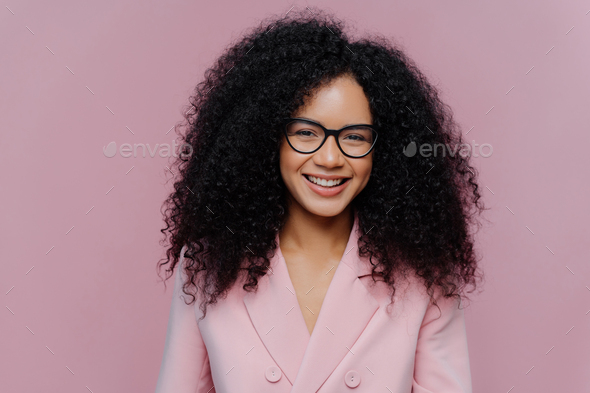 Close Up Portrait Of Happy Curly Haired Woman Has Gentle Smile On Face