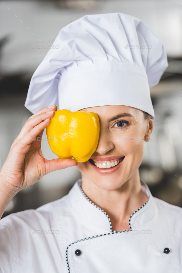smiling chef covering eye with bell pepper at restaurant kitchen Stock ...