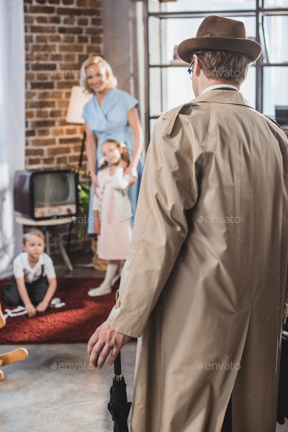 back view of father coming home and looking at happy family, 1950s ...