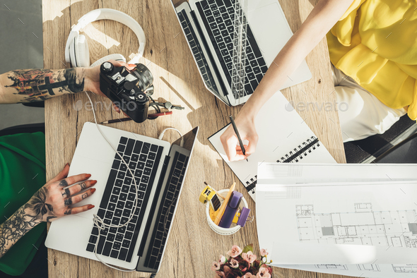 overhead view of blogger and photographer working at table together in ...