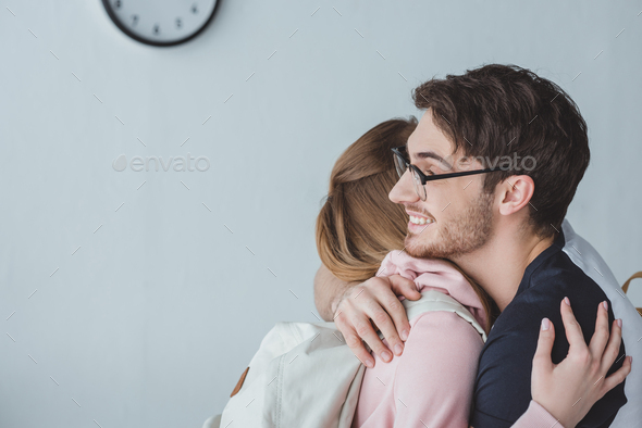 happy man hugging girl with backpack Stock Photo by LightFieldStudios