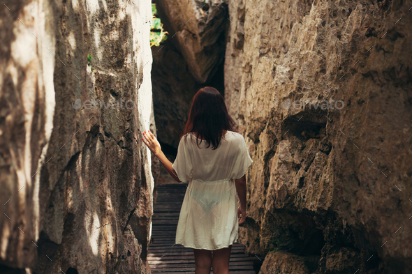 rear view of woman walking between cliffs at Ang Thong National Park ...