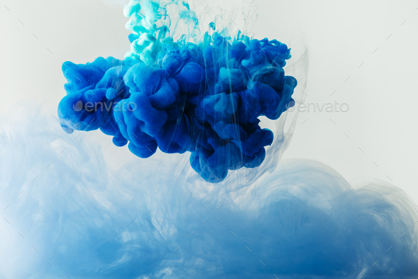 Close up view of mixing of blue and turquoise ink splashes in water ...