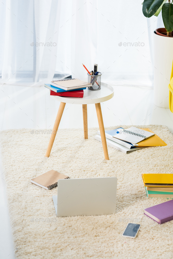 close up view of laptop, notebooks and folders arranged on floor at ...