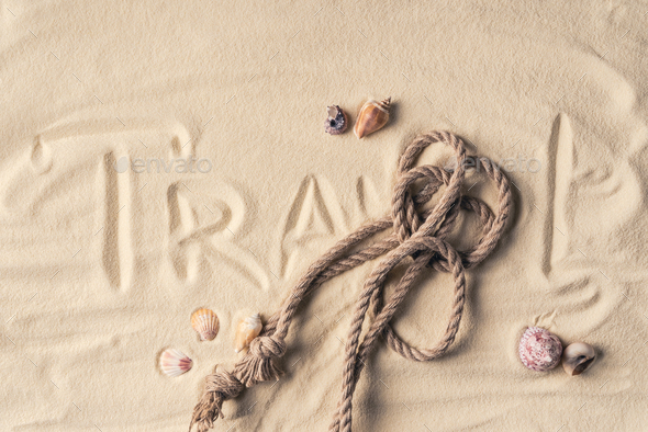 Rope and shells on sandy beach with rope and Travel inscription Stock ...