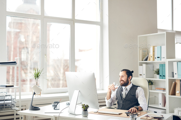Drinking water while working with computer Stock Photo by Media_photos