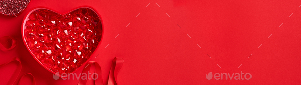 Open red heart box, ribbon and many small hearts inside on scarlet ...
