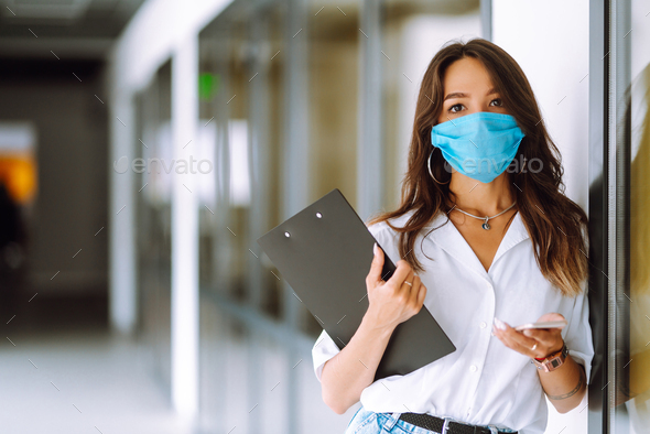 Office worker with face mask working in the office. Concept of ...