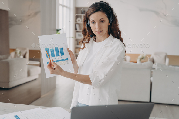 Woman has corporate internet session. Young pretty leader shows charts ...