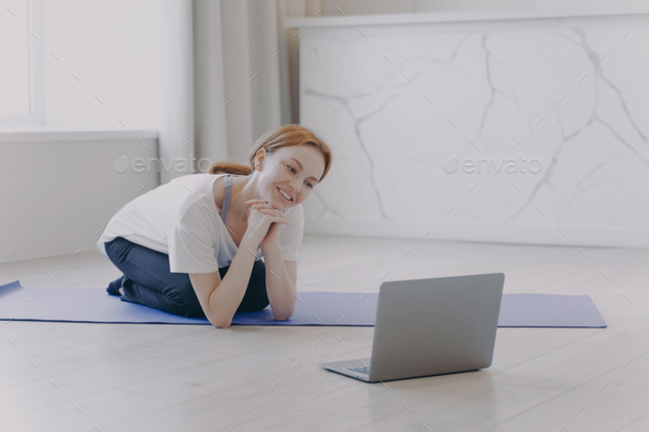 Smiling white woman has remote personal training and talking in front ...