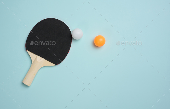 Wooden tennis racket for ping pong and a plastic ball on a blue ...