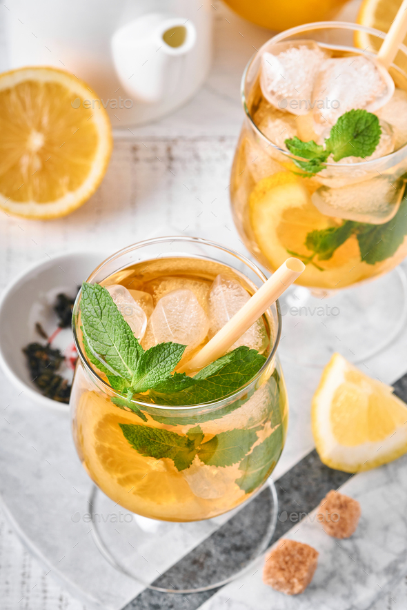 Traditional iced tea with lemon and ice in tall glasses on marble table ...