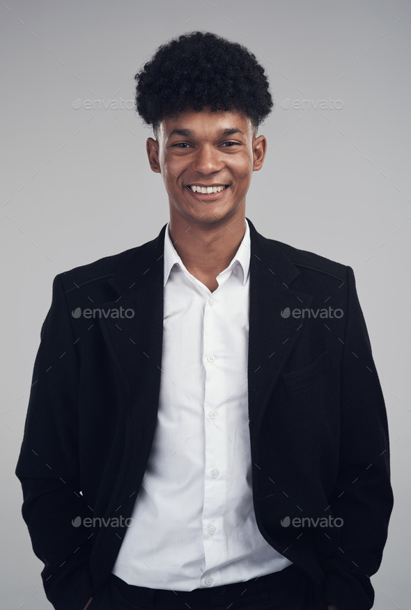 Studio portrait of a confident young businessman posing against a grey background Stock Photo by ...