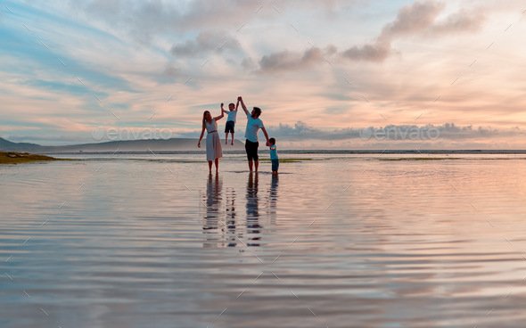 Shot of a beautiful family bonding while spending a day at the beach ...