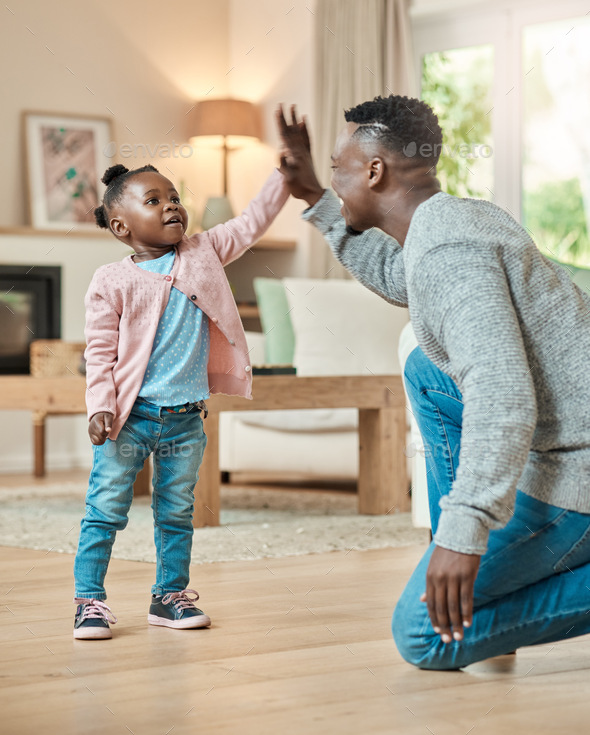 Full length shot of an adorable little girl high fiving her dad in the ...