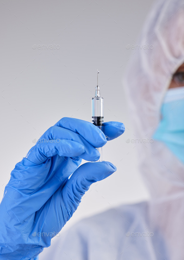 Shot of a nurse holding a needle against a studio background Stock ...