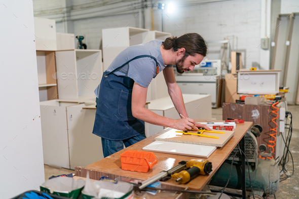 Carpenter working on the woodworking desk and furniture handmade with ...
