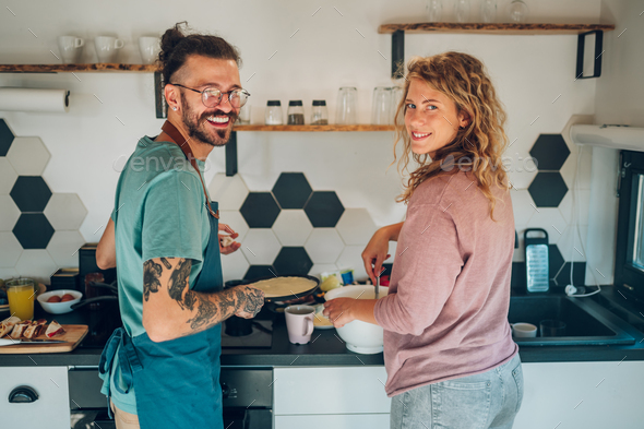 Young couple making breakfast together in the kitchen at home Stock ...