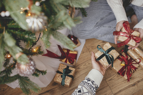 Family exchanging christmas gifts under christmas tree in festive room ...