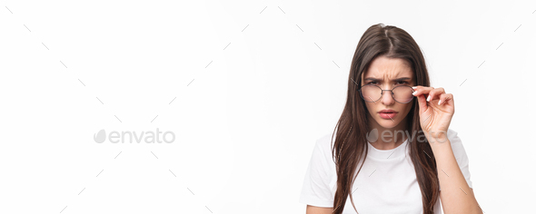 Close-up portrait of suspicious young serious-looking woman, look from ...