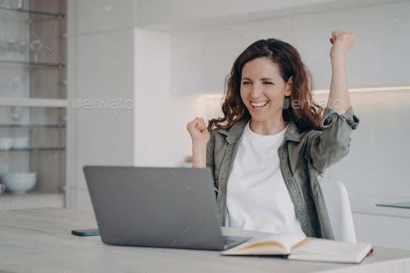 Successful young spanish woman has video call on computer. Excited girl ...