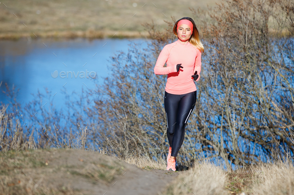 Young fitness woman running in the morning in cold sunny weather Stock ...