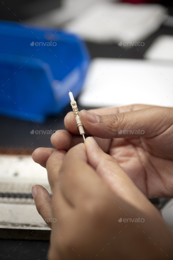 Technician cleaving an optical fiber, a crucial process for a good ...