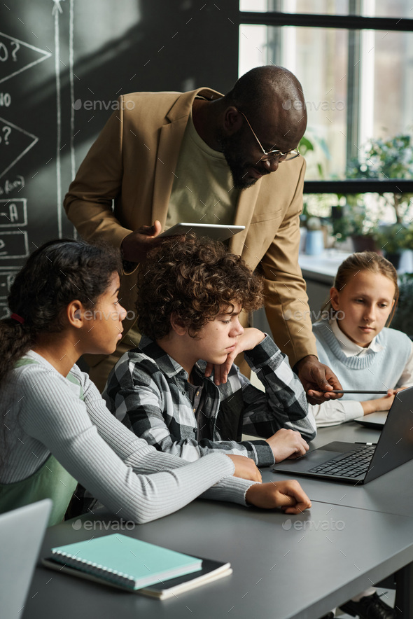 Teacher showing the work of computer program at lesson Stock Photo by ...
