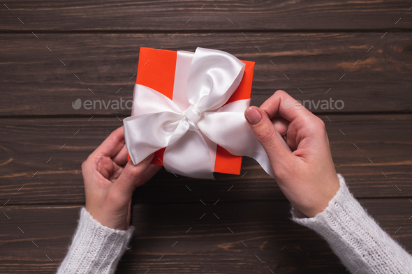 Women's hands untie the white ribbon on Christmas gift Stock Photo by ...