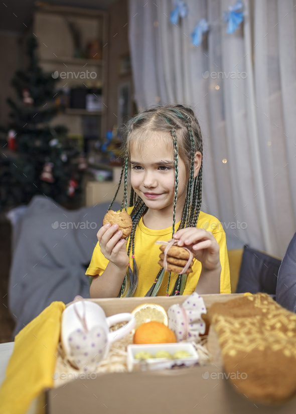 Girl packing care box with honey, cookies and knitted socks for ...