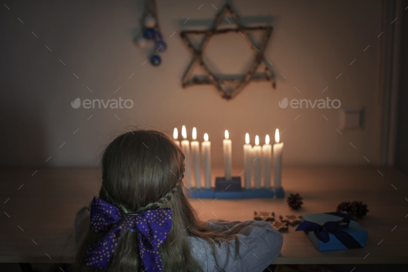 Family celebrating Hanukkah, dad lighting candles on traditional ...