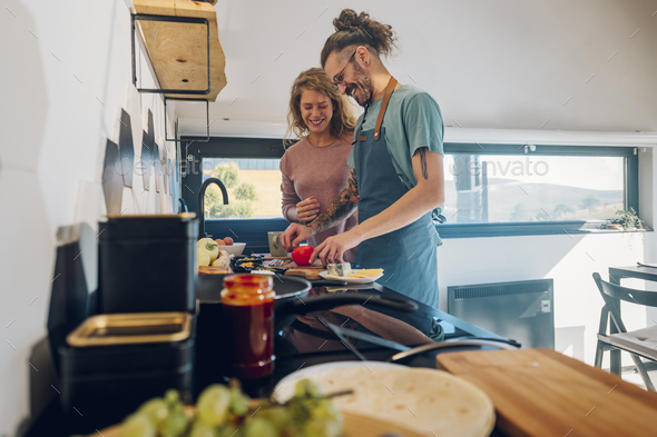 Young couple making breakfast together in the kitchen at home Stock ...