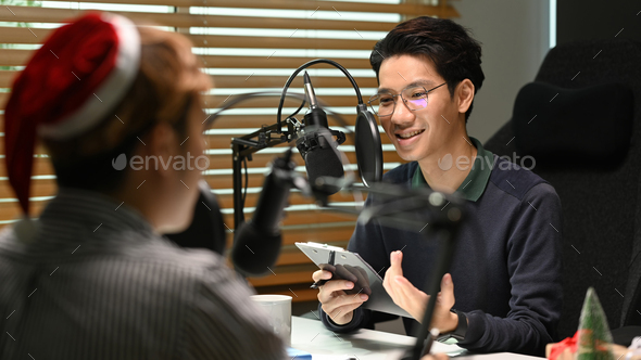 Two young bloggers looking and talking each other while recording ...