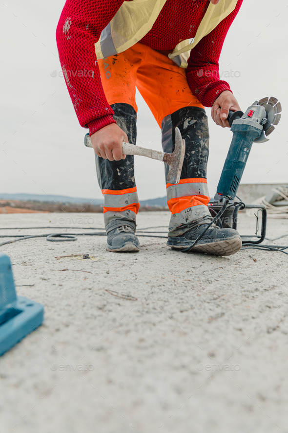 Vertical shot of a worker doing installation work during construction ...