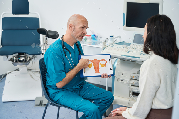 Gynecologist demonstrates structure of the female organs to the patient ...