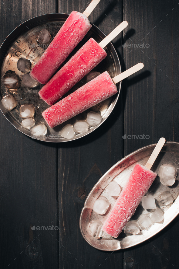 Frozen ice pop on wooden background Stock Photo by LightFieldStudios
