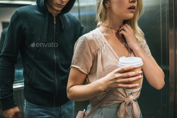 cropped view of aggressive robber stealing pendant from womans neck in ...