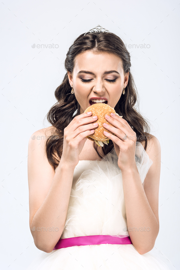 hungry young bride in wedding dress eating hamburger isolated on white ...